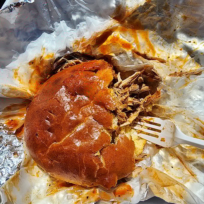A pulled pork sandwich that requires both hands and possibly a bib. The bread is just transportation for what really matters here.