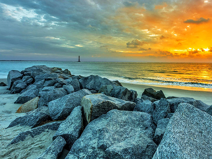 Rocky shores and golden skies frame the distant lighthouse, creating a scene worthy of the most discerning desktop wallpaper collector.