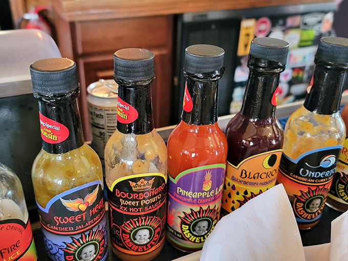 Hot sauce bottles lined up like tiny soldiers, each ready to wage delicious war on whatever dish dares to be bland.