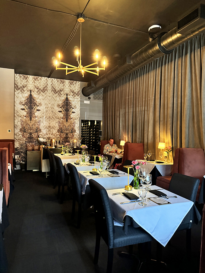 The dining room's moody elegance says "special occasion" while somehow also whispering "come as you are, just bring your appetite."