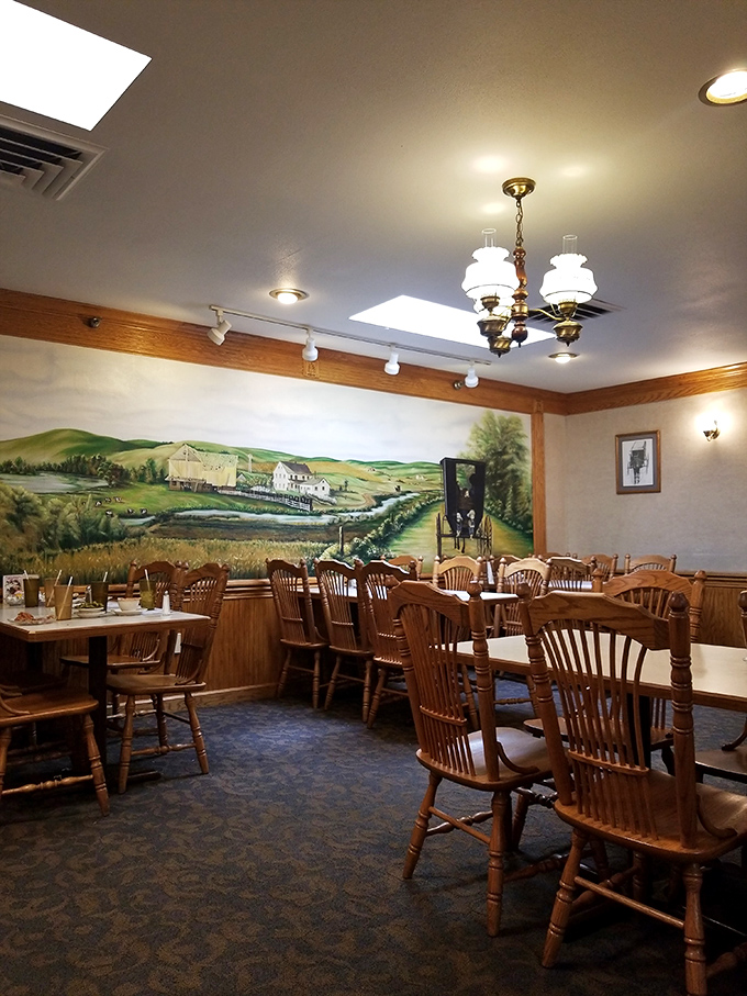Rustic wooden chairs face a pastoral mural that serves as a window to simpler times&mdash;dining with a side of nostalgia.