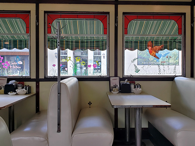 Cream-colored booths frame windows that showcase small-town America, turning every meal into dinner and a show.