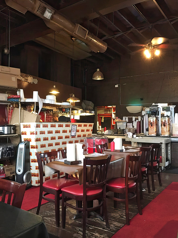 Red vinyl booths and wood-paneled walls create the quintessential American barbecue dining experience perfectly.