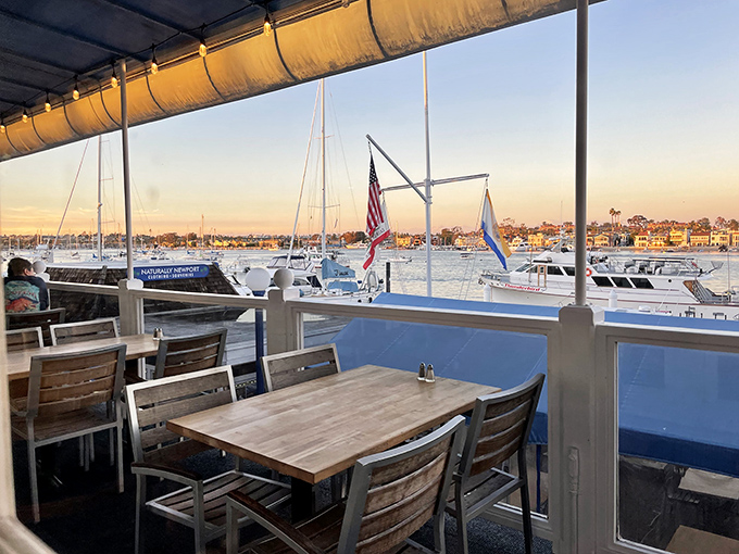 The golden hour transforms Newport Landing's outdoor seating into front-row tickets to nature's most spectacular light show, with boats providing the perfect props.