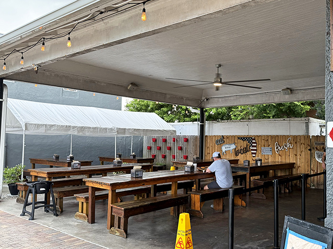 The covered patio—where strangers become friends united by the universal language of "did you try the brisket yet?"