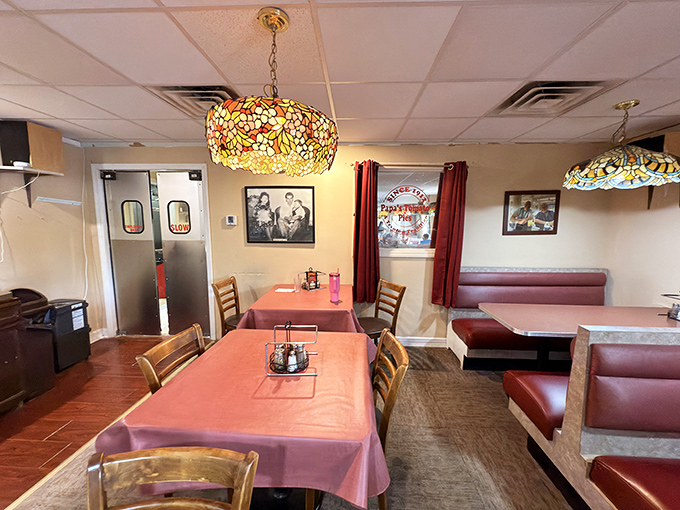 The heart of the operation. Pink tablecloths and wooden chairs create that perfect balance of comfort and no-nonsense dining that defines great pizza joints.