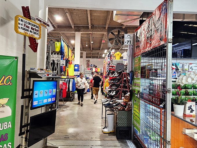 Shoppers navigate the retail maze with practiced precision. Signs overhead serve as retail constellations guiding customers through this commercial cosmos.