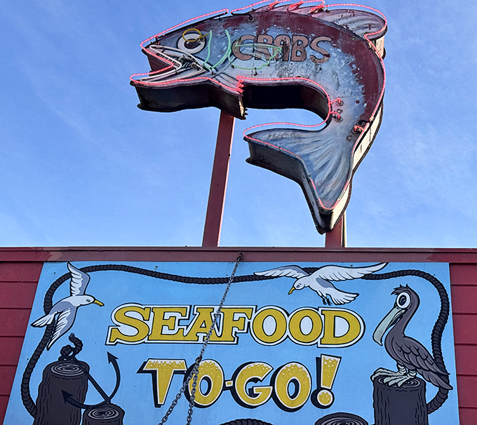That iconic fish sign announcing "SEAFOOD TO-GO!" has guided hungry travelers like a maritime North Star for generations of coastal wanderers.