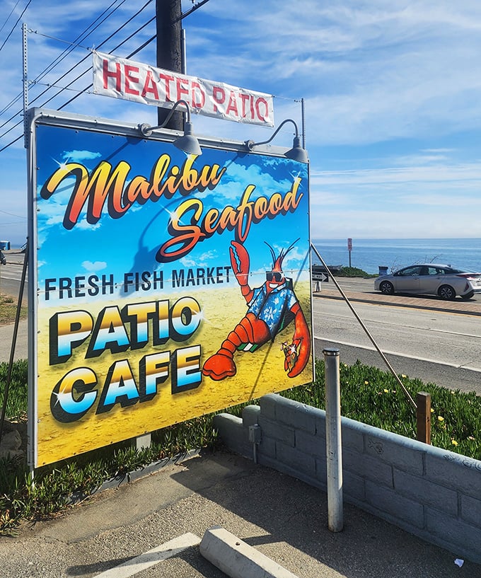 The roadside sign stands as a beacon of hope for hungry travelers, promising seafood salvation just steps from Pacific Coast Highway's scenic curves.