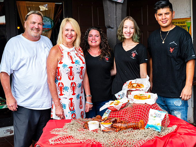 Happy customers and staff pose with a seafood feast fit for Neptune himself. This spread would make Poseidon put down his trident and pick up a fork.