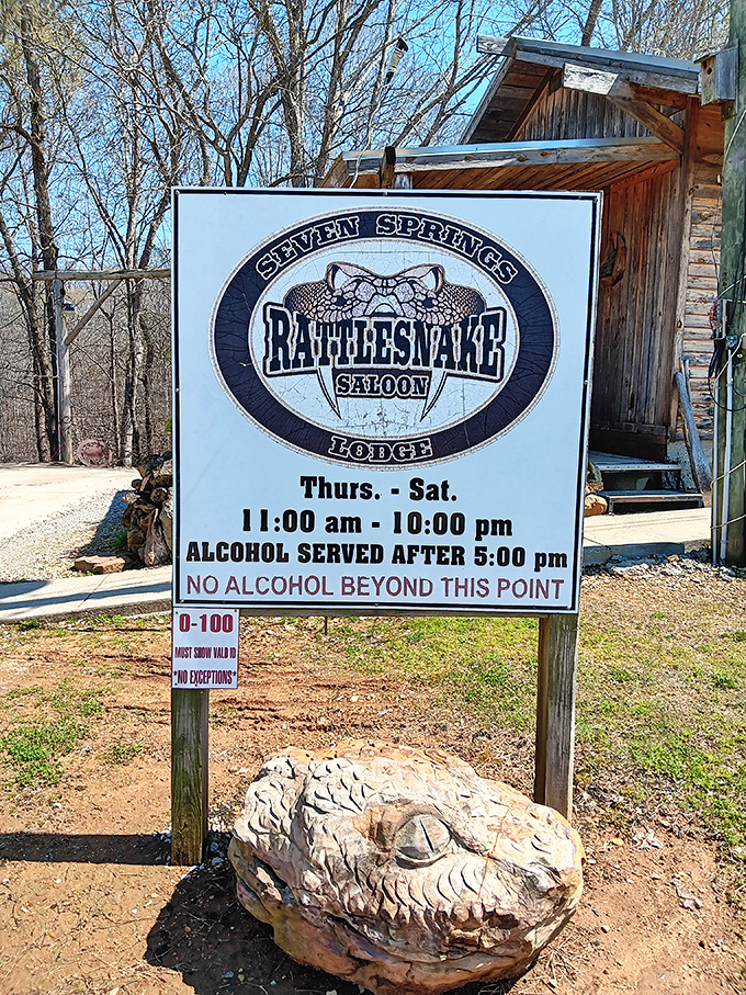 Operating hours posted with a rattlesnake sculpture guard&mdash;nature's way of saying "We're casual about most things, but punctuality isn't one of them."
