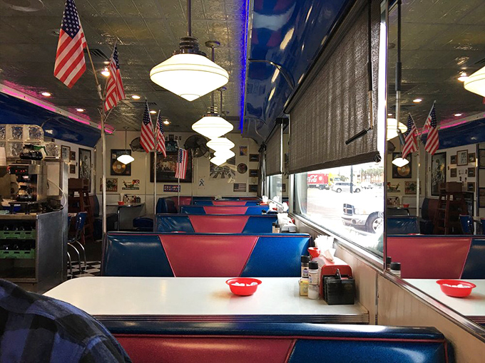 Red and blue booths stretch toward infinity, like an Edward Hopper painting with better lighting.