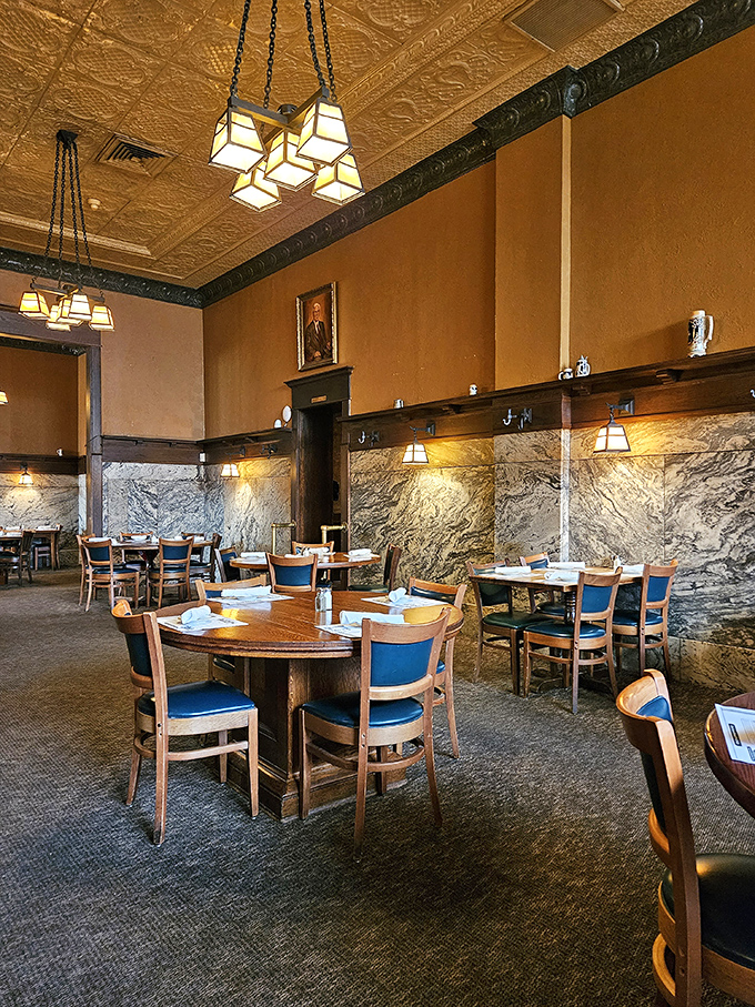Marble wainscoting meets warm wood and classic lighting in a dining room where conversations flow as smoothly as the wine service.