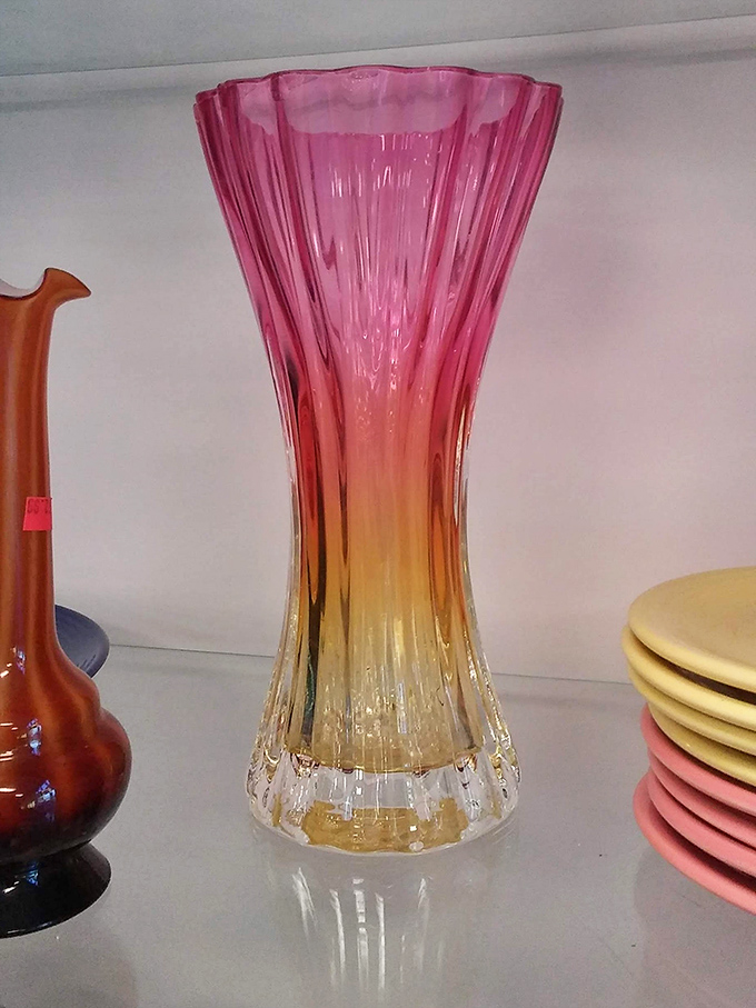 This sunset-hued glass vase catches light like captured sunshine, waiting to brighten someone's dining table.