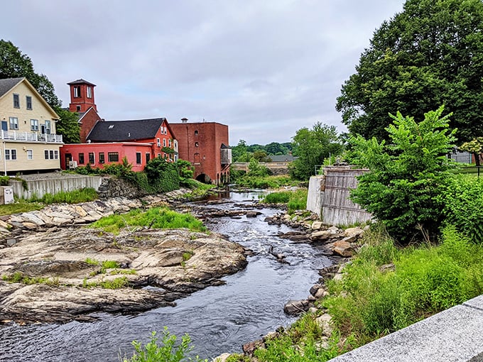 The Exeter River carves its ancient path past historic mill buildings, a liquid timeline connecting the town's industrial past to its picturesque present.