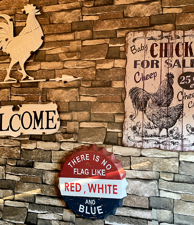 Rustic stone walls adorned with Americana &ndash; where "Welcome" signs and vintage chicken advertisements create the perfect backdrop for comfort food consumption.