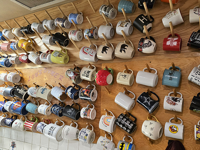 A wall of coffee mugs telling stories better than most museums, each one representing a regular who found home here.