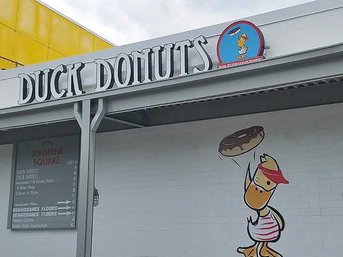 The playful duck logo and cheerful signage promise the same lighthearted approach to their made-to-order donut creations inside.
