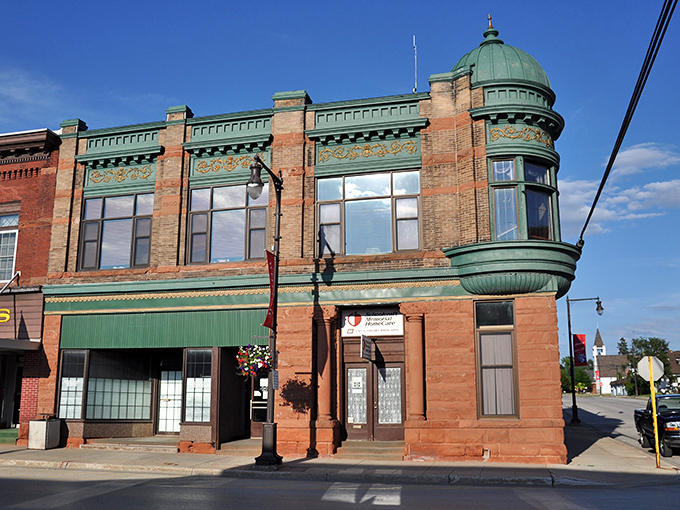 The emerald-topped historic building in Manistique whispers stories of a time when architecture had personality and flair.