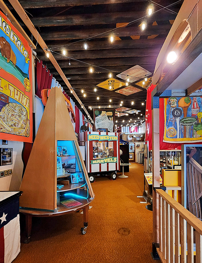Colorful exhibits line the narrow aisle, creating a funhouse-like journey through America's obsession with the oversized and outlandish.