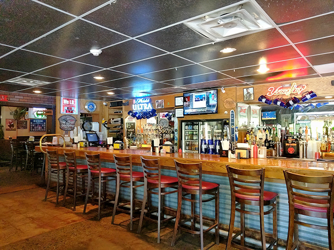 The bar where stories get better with each telling, and the glow of neon signs competes with the warmth of Southern hospitality.