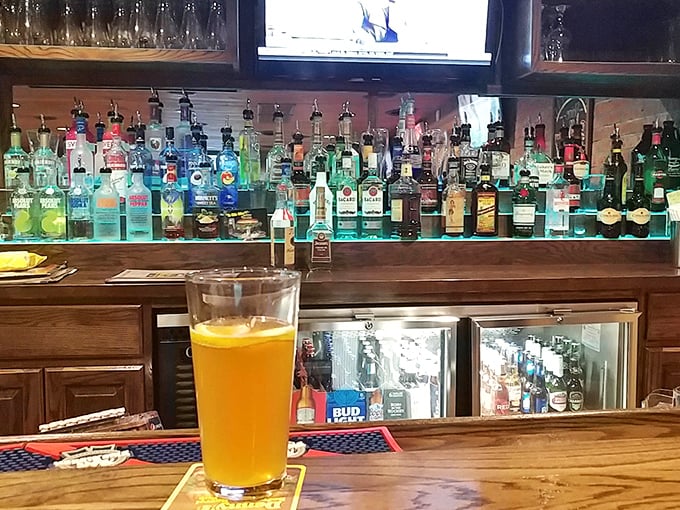 The illuminated liquor display glows like a beacon of hope for those who just realized what they ordered weighs more than a newborn baby.