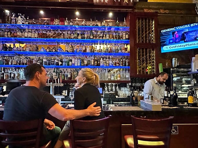 The bar scene at Rock'N Fish offers front-row seats to mixology magic, with blue lighting that makes every drink look like an ocean-inspired potion.