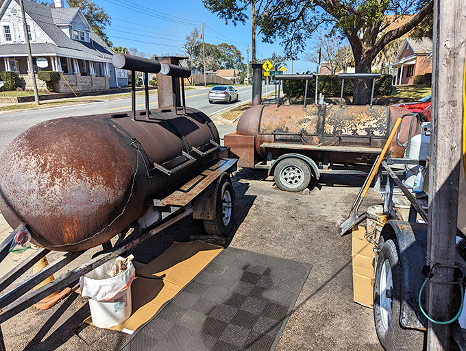 These weathered smokers tell stories of countless overnight sessions, their rusted exteriors bearing the honorable battle scars of thousands of barbecue triumphs.