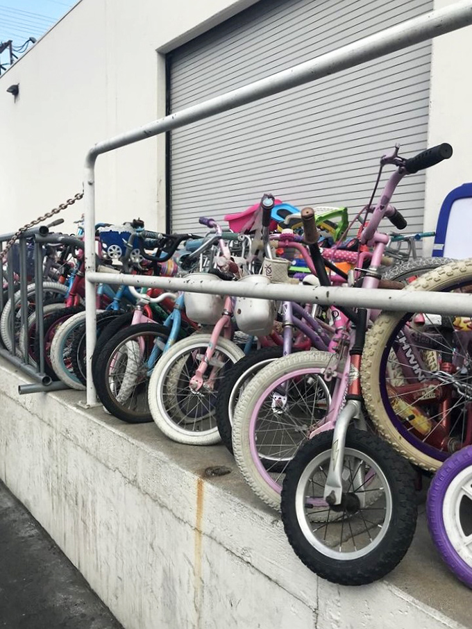 Bicycle brigade! Kids' bikes in every color of the rainbow stand ready for new adventures. That pink one has "first day without training wheels" written all over it.