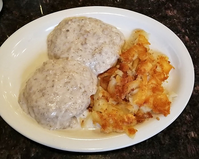 Biscuits smothered in country gravy alongside crispy hash browns&mdash;a plate that whispers "nap time" even as you eagerly dig in.