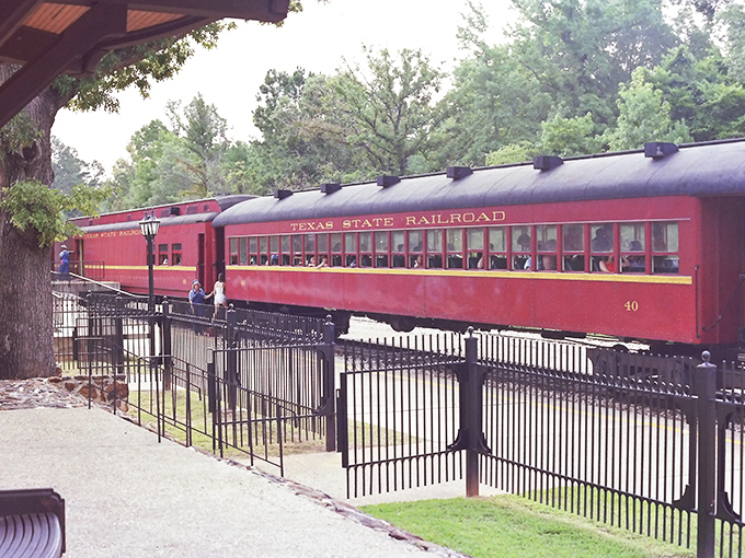 The crimson coaches of the Texas State Railroad offer a moving postcard of East Texas, framed by wrought iron and anticipation.