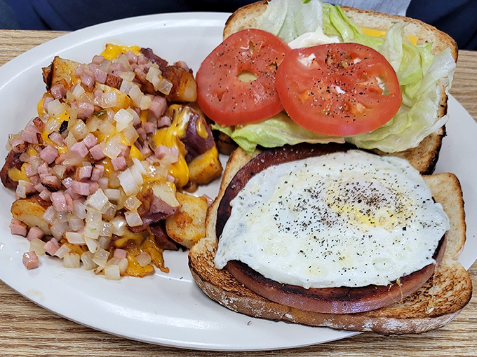A breakfast sandwich that understands the importance of architectural integrity—every layer visible, like a delicious cross-section of morning happiness.