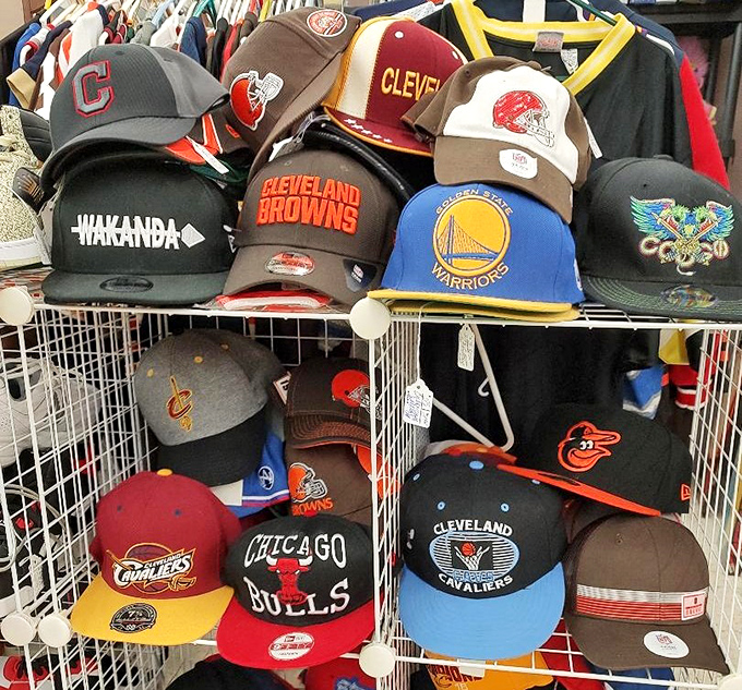 A hat collection that spans team loyalties and generations. Cleveland Browns fans and Warriors supporters finding rare common ground on adjacent shelves.