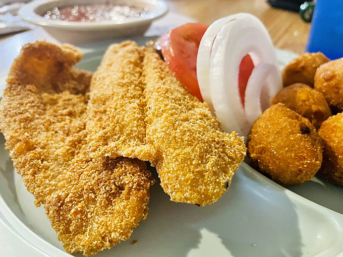 Golden-fried catfish with a cornmeal crust so perfect it practically shatters at first touch, served with classic Southern sides that demand equal attention.