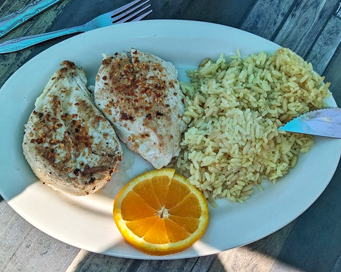 For lighter fare that doesn't sacrifice flavor, the grilled chicken with rice pilaf and a bright orange garnish offers a satisfying alternative to the fryer's siren call.