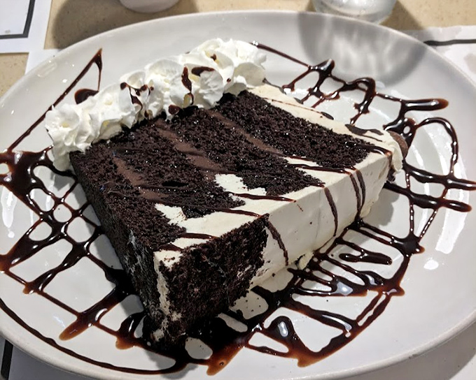 A chocolate cake slice so decadent it should come with its own warning label: "May cause spontaneous happiness and the unbuttoning of pants."