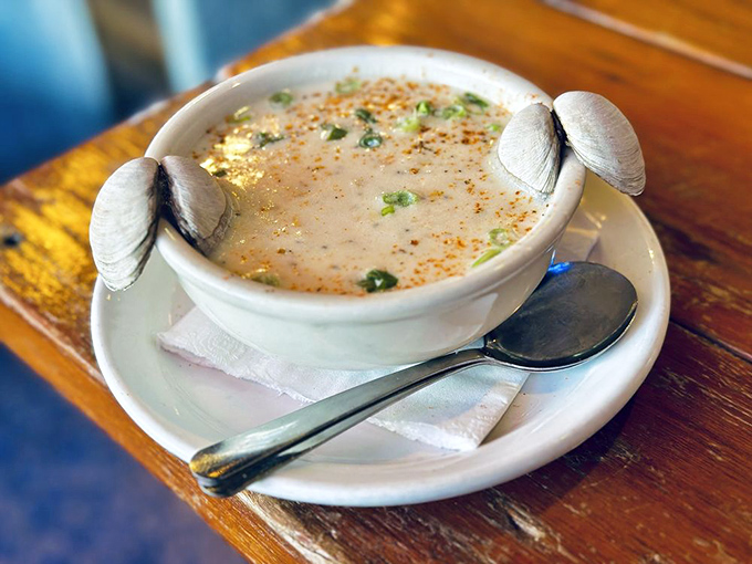 This clam chowder, adorned with its own mollusk garnish, is like a warm hug from the ocean itself.