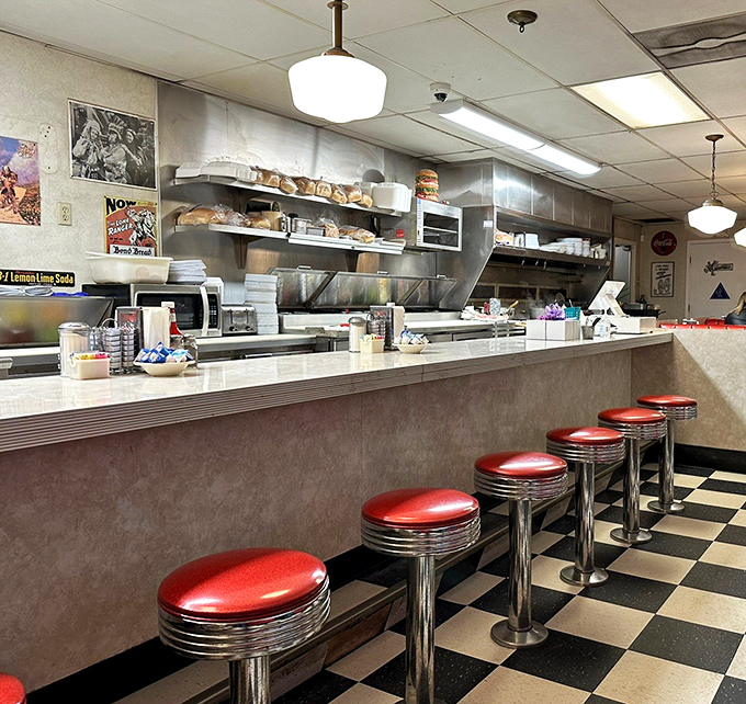 The counter where solo diners find community, watching the choreographed dance of cooks and servers while perched on those iconic red stools.