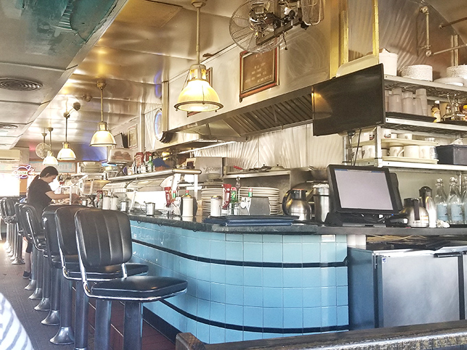 Counter seats where life's problems get solved between hash browns and second coffee refills.