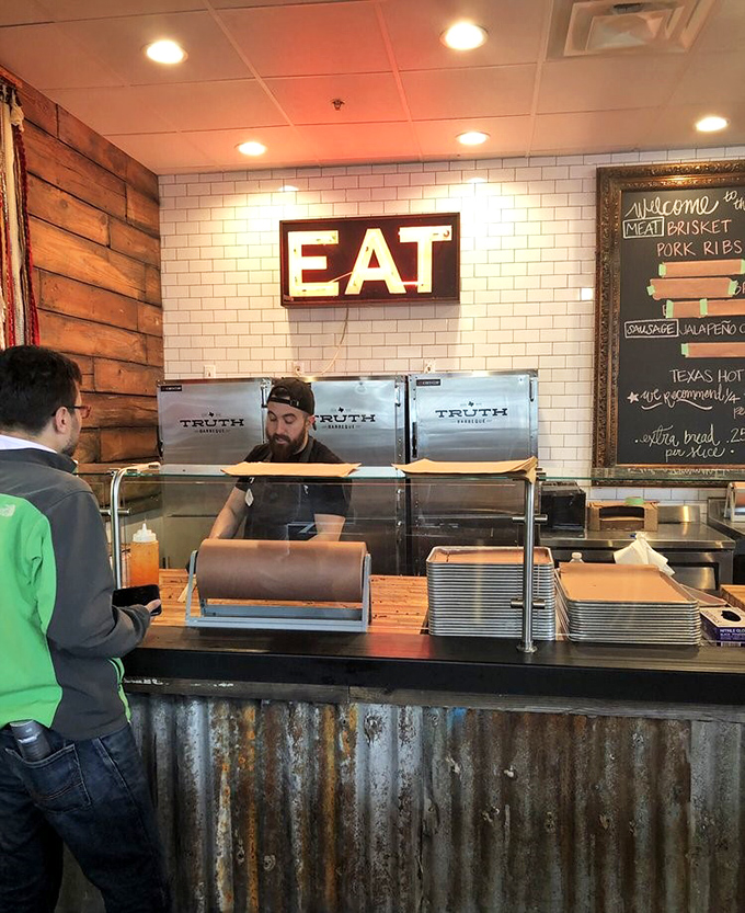 The counter where dreams come true, one slice of brisket at a time. The simple "EAT" sign above says everything you need to know.