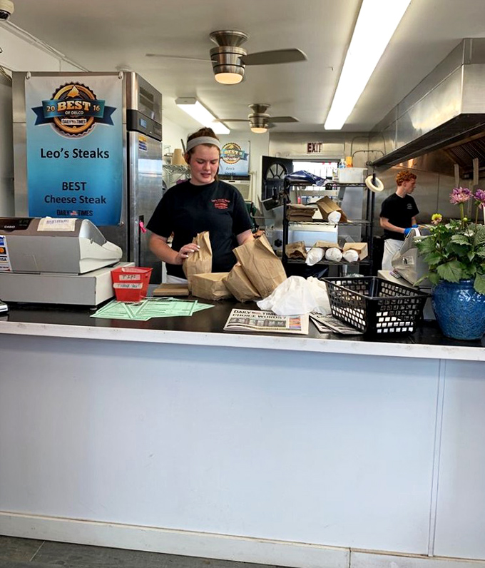 The counter staff—sandwich artists who could probably assemble your order blindfolded. Years of practice make perfect cheesesteaks.