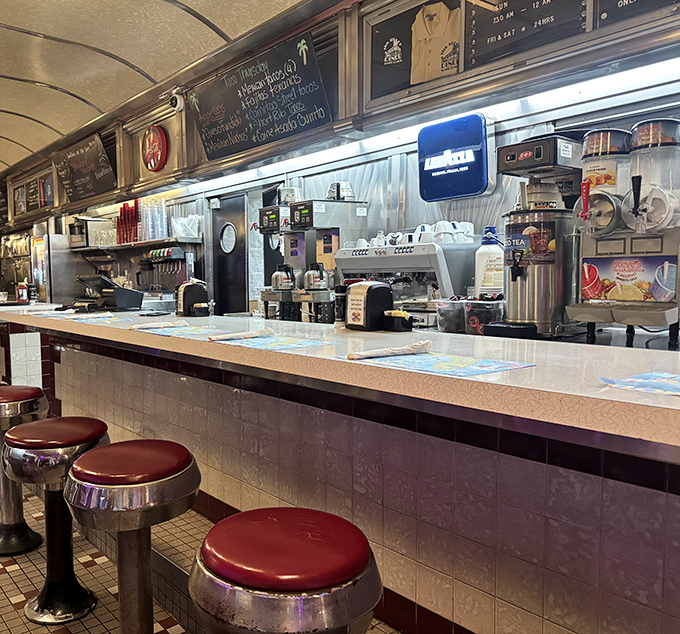 Outdoor seating under burgundy umbrellas creates the perfect spot to enjoy your meal while soaking in the vibrant Miami Beach atmosphere.