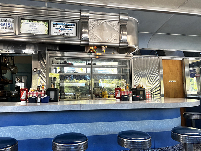 A counter where strangers become friends over coffee refills. The stainless steel backdrop is the stage where breakfast theater unfolds every morning.