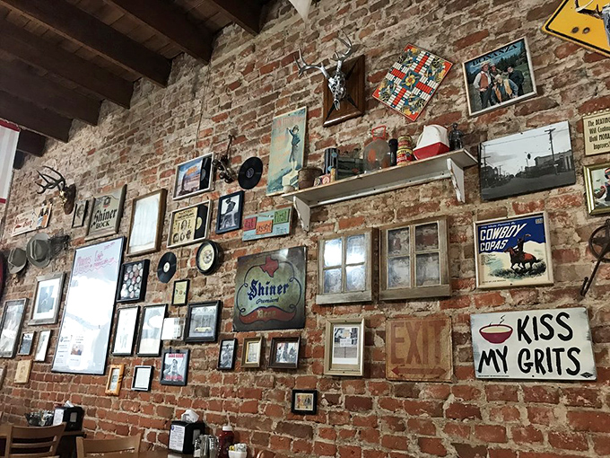 The wall doesn't just display decorations&mdash;it showcases Texas culture one frame at a time. That "Kiss My Grits" sign isn't just funny, it's a philosophy.