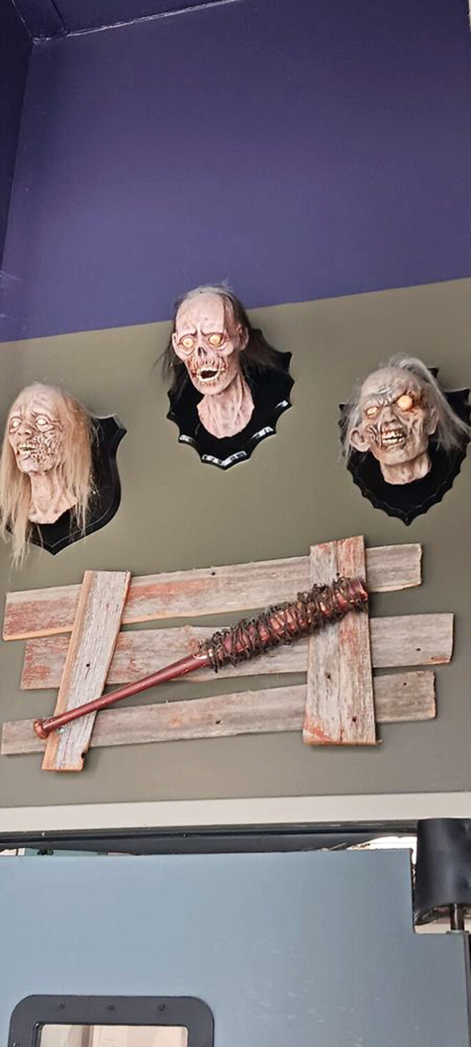 Mounted zombie heads watch over diners with eternal hunger. They've found their forever home among wooden boards and post-apocalyptic weaponry.