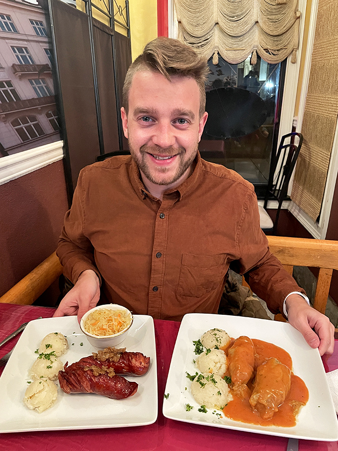 A satisfied customer shows off two gorgeous plates, proving that bringing a friend means you can try twice as much.