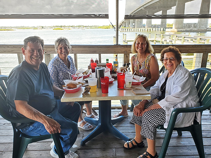 Happy diners enjoying the fruits of the sea. The best conversations happen over seafood and sunset views.