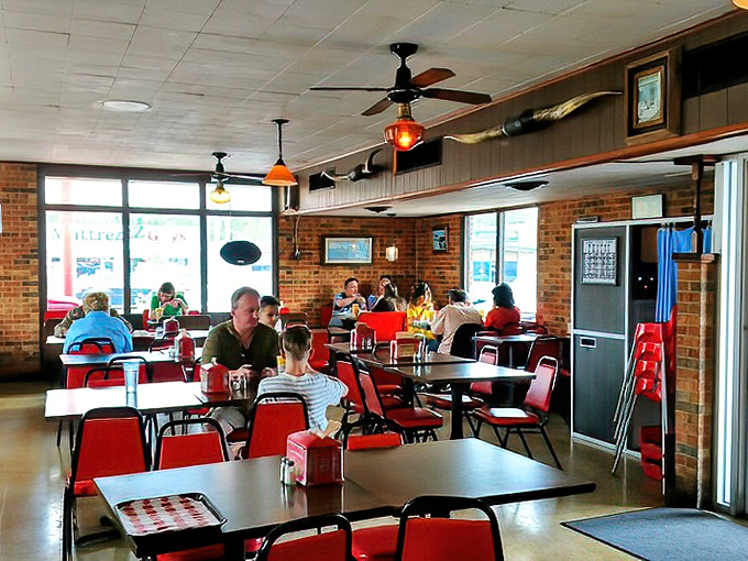 Families filling the red chairs and booths prove that great food brings generations together better than any app.