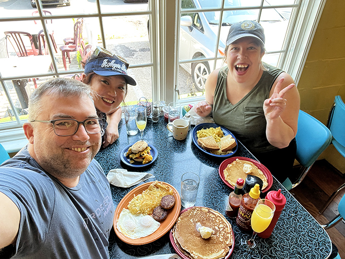 Happy faces around a table loaded with breakfast classics&mdash;the universal language of morning contentment.