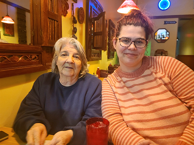 Beneath the cozy glow of hanging lights, two generations share stories and supper — proof that the real heart of any diner isn’t on the menu, but at the table.